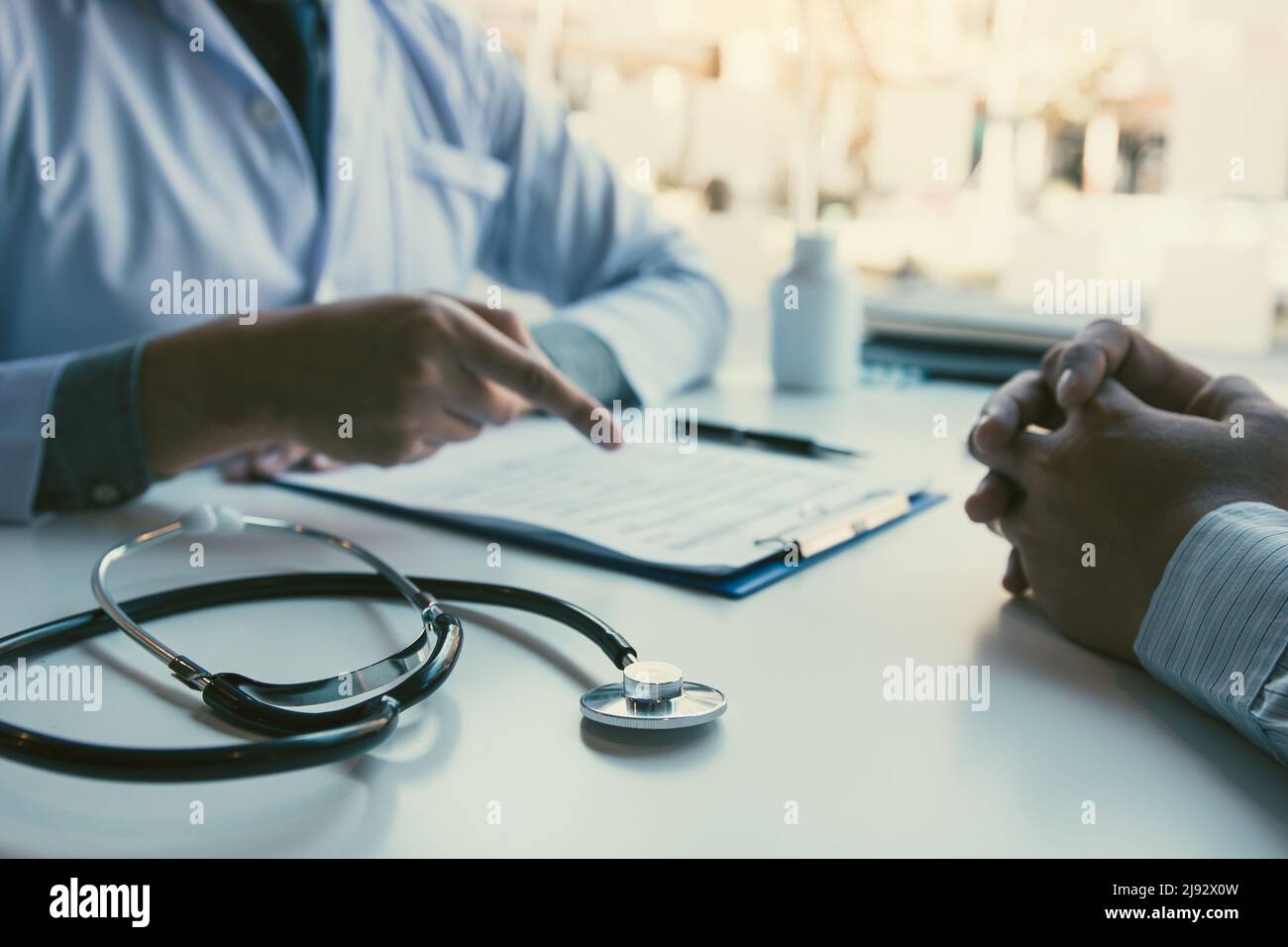 Doctor hand holding pen writing patient history list on note pad and ...