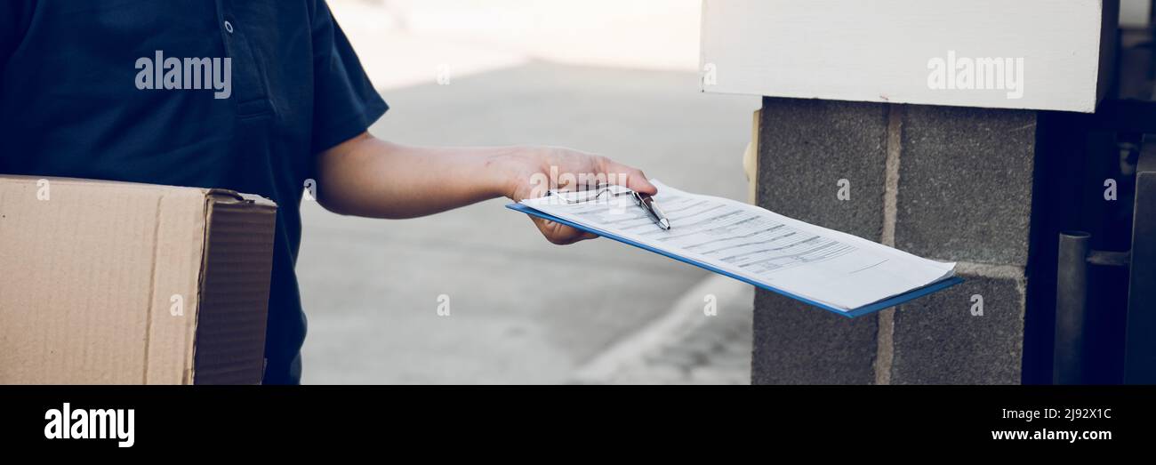 Young asian man smiling while delivering a cardboard box to the woman ...