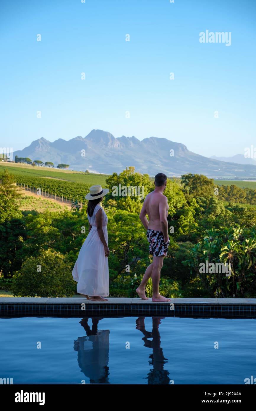 couple man and women in swimming pool looking out over the Vineyards ...