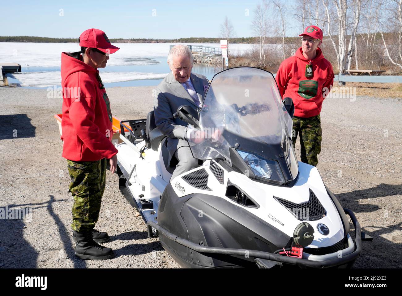 Prince Charles, centre, is shown the operation of a snowmobile during a ...