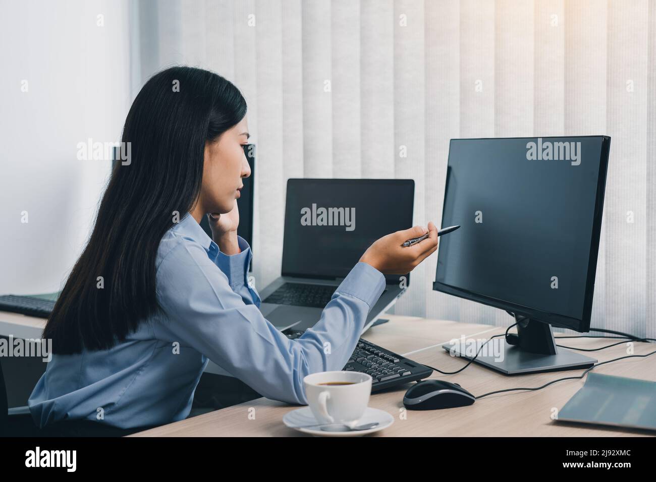 Concentrated Asian Woman Brainstorming While Coding Data On Desktop Pc While Working On Computer