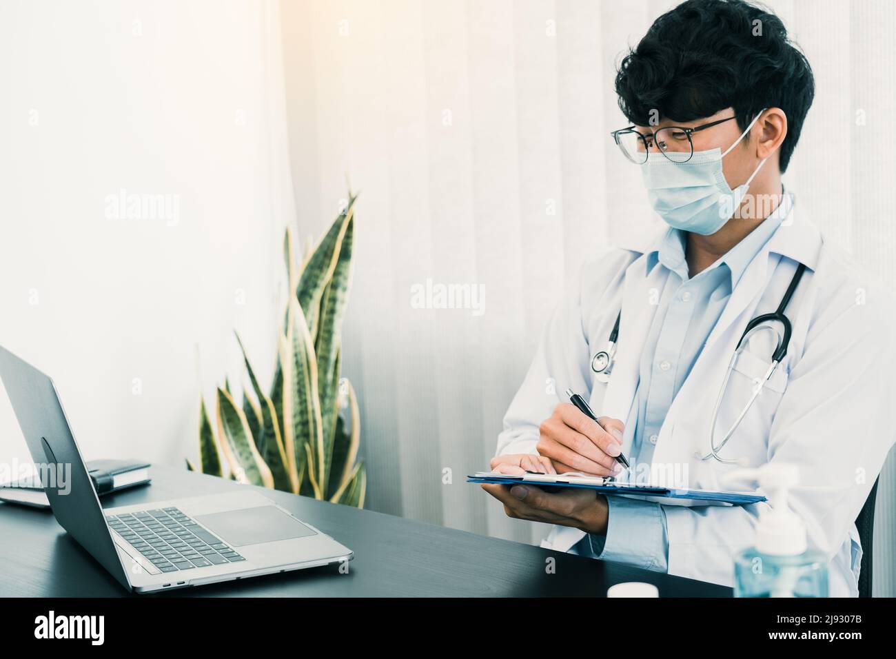 Doctor hand holding pen writing patient history list on clipboard about ...