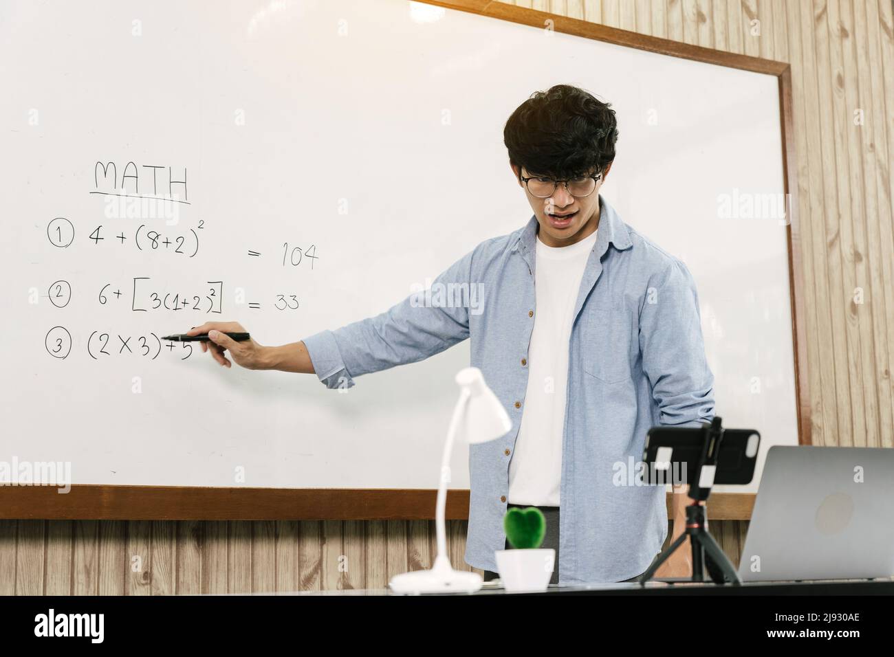 Teacher explaining the numbers on the board while video calling with ...