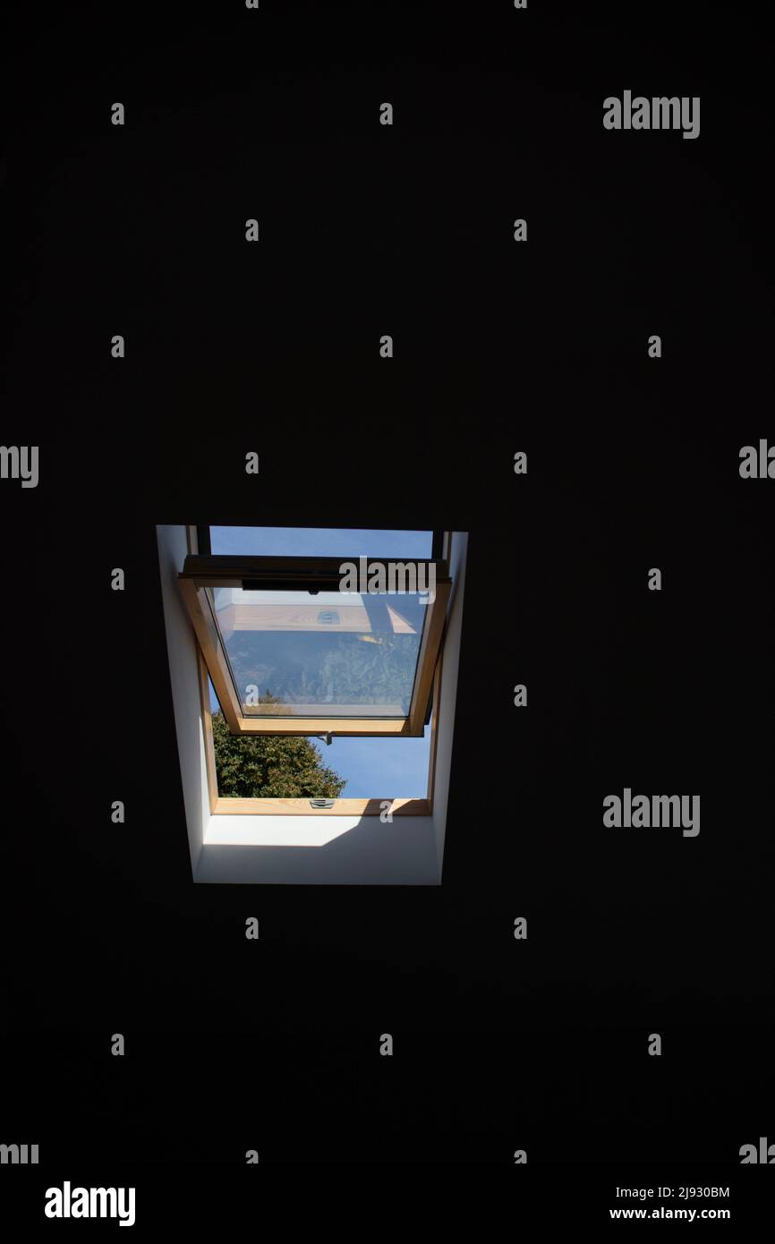 Open roof window skylight. View of the sky and trees from the window ...