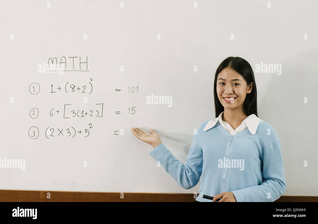 Asian female teacher is teaching students at the classroom while ...