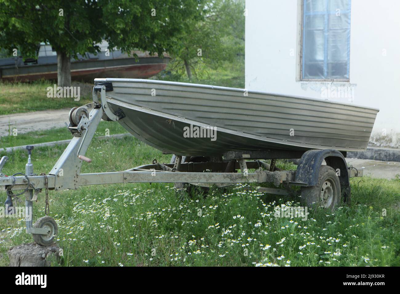 Metal boat on wheels near the house Stock Photo - Alamy