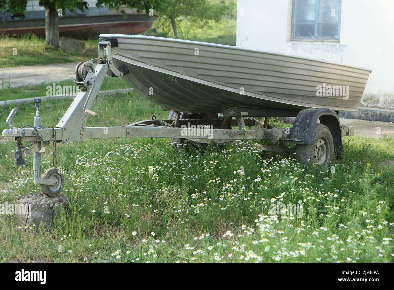 Metal boat on wheels near the house Stock Photo - Alamy