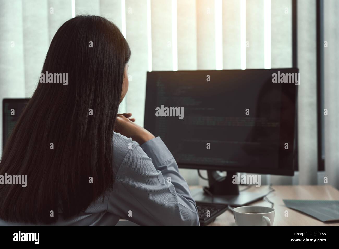 Asian woman software developers sitting in front of computers looking ...