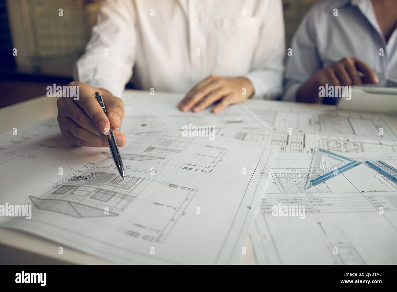 Architects engineer working with blueprints on table and discussing ...