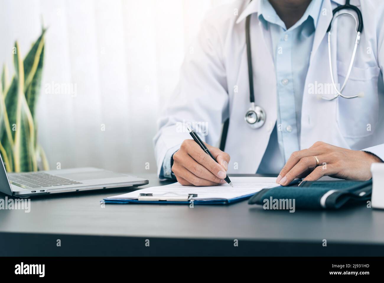 Doctor hand holding pen writing patient history list on clipboard about ...