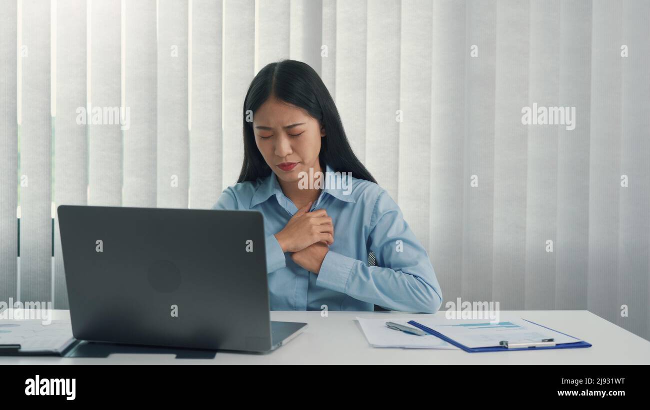 Asian woman felt pain in her chest while sitting at work Stock Photo ...
