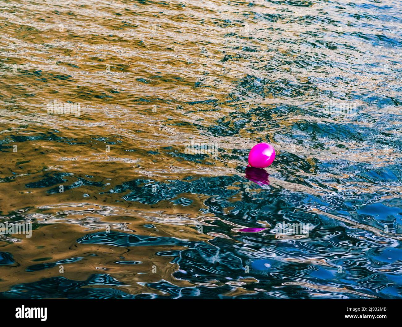 Shot of an air balloon floating in the water Stock Photo - Alamy
