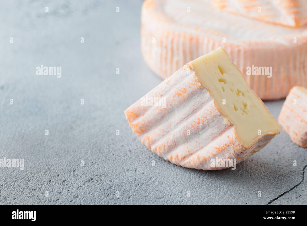 Sliced soft cheese with mold on a wooden board on a white background ...
