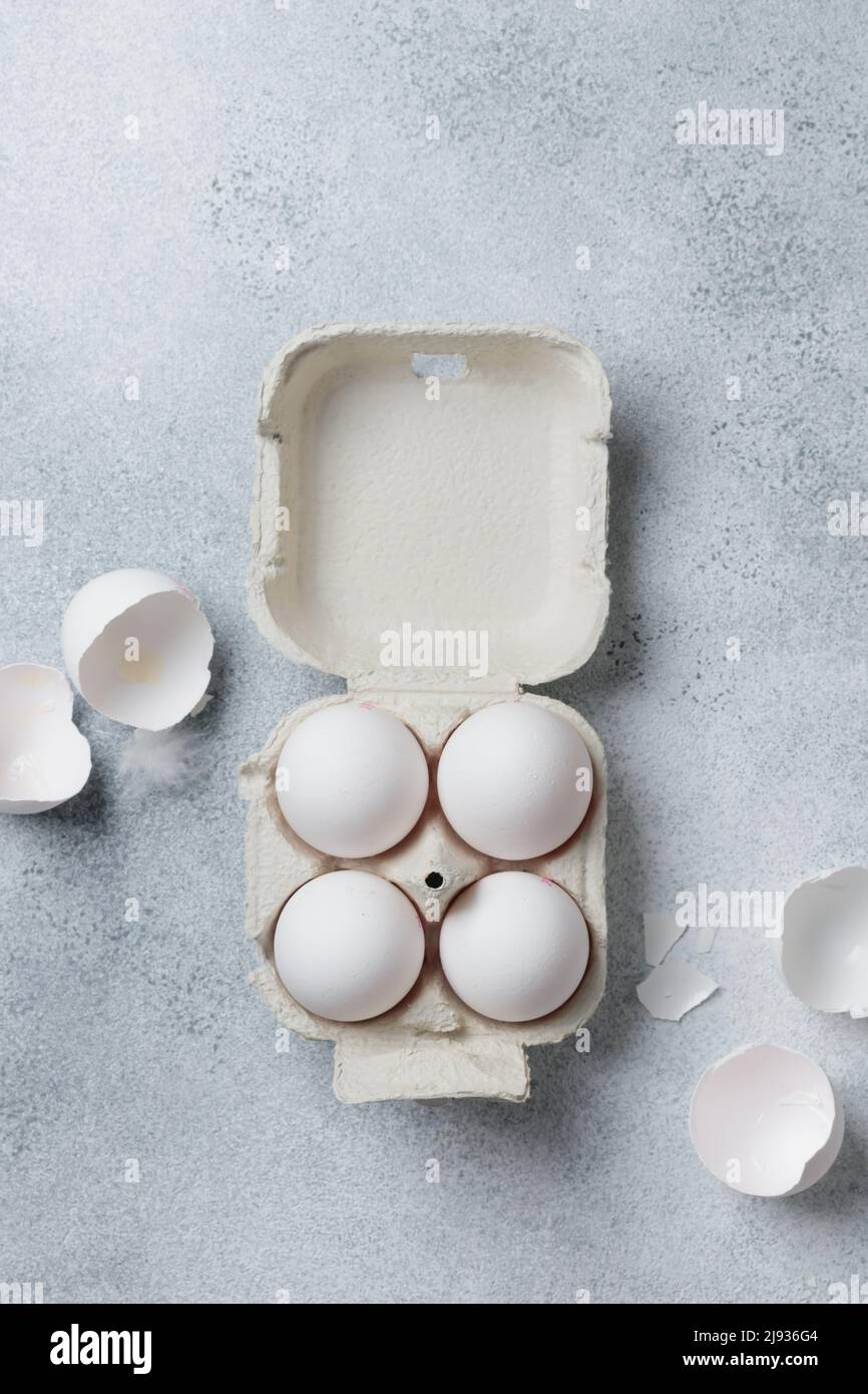 White eggs in a small paper container box top view on a neutral ...