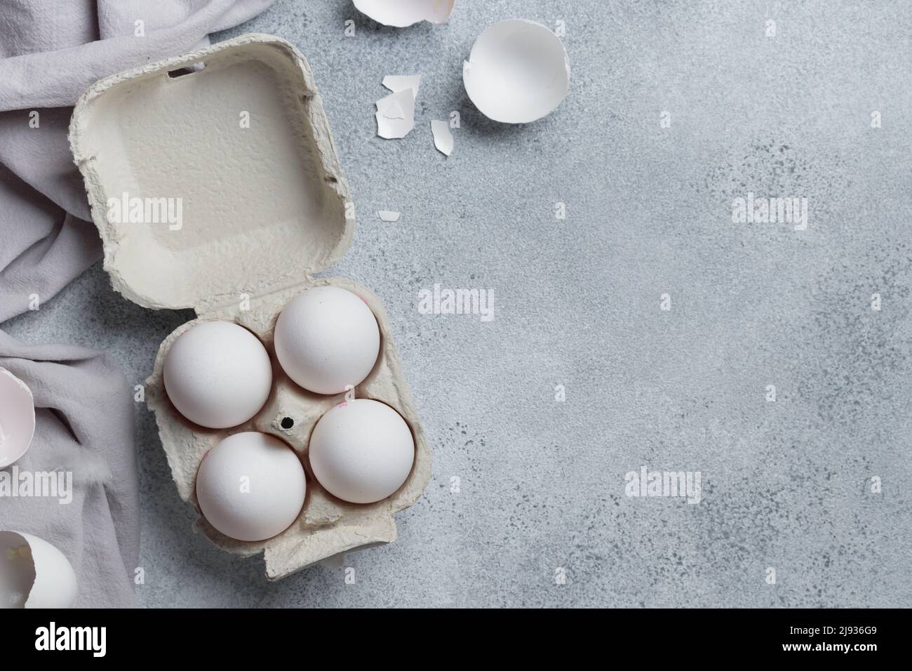 White eggs in a small paper container box top view on a neutral ...