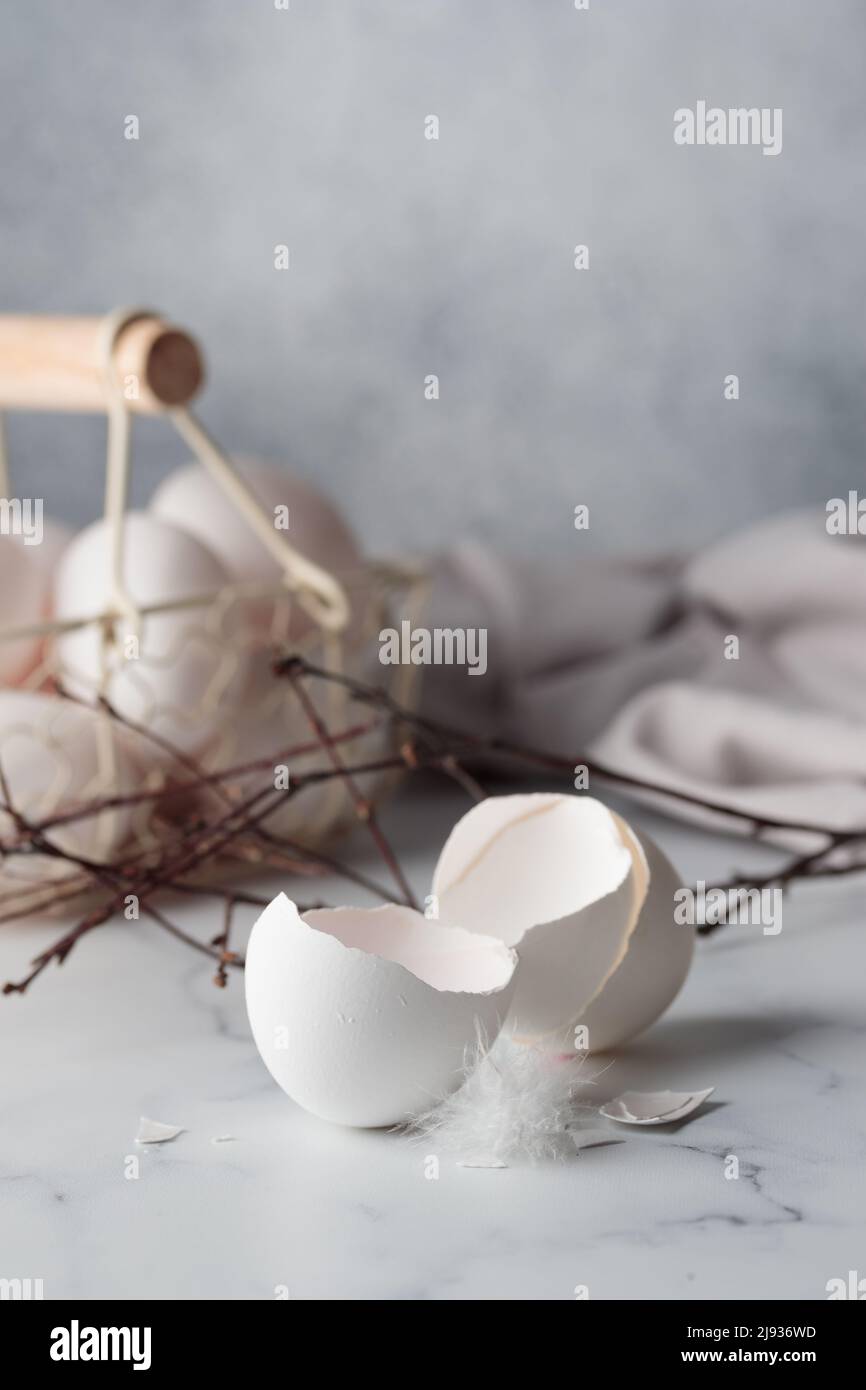 white egg shells on a table with a white basket Stock Photo - Alamy