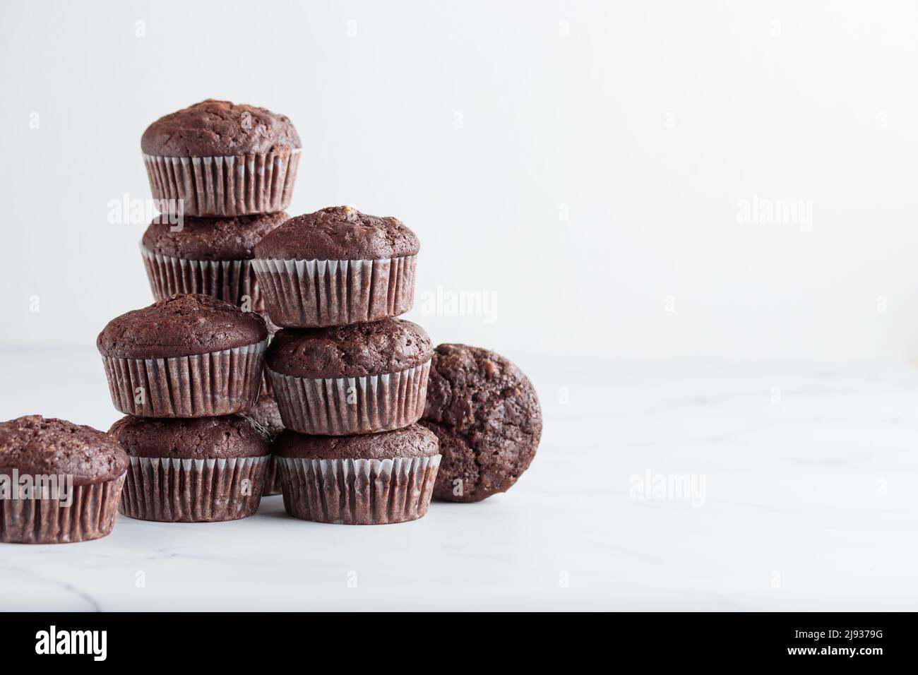 Pile of chocolate muffins on a white background Stock Photo - Alamy