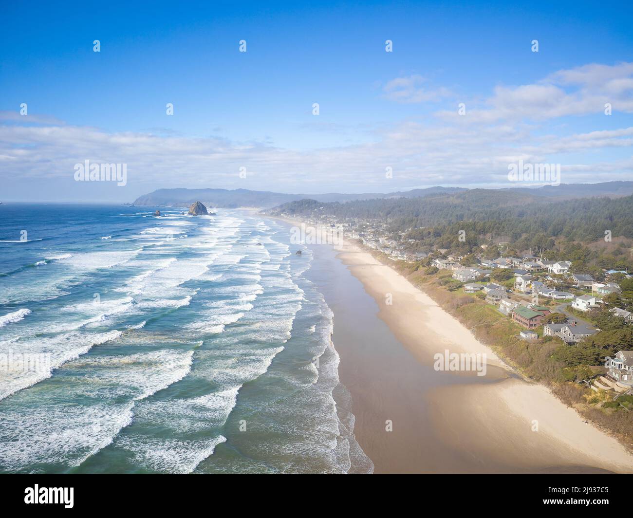 Panoramic shot. Ocean coast. White sandy beach. Hilly area. Small green ...