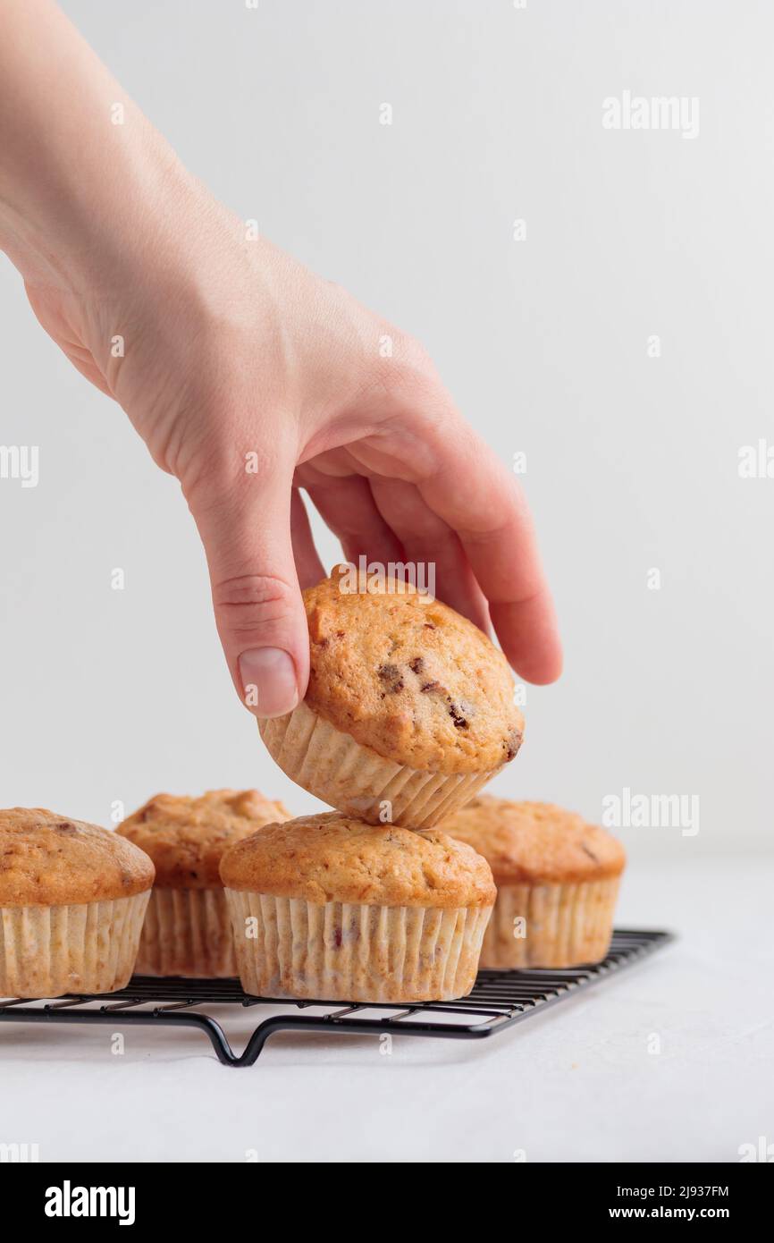 Vanilla fresh baked muffins on a white table with hand Stock Photo - Alamy