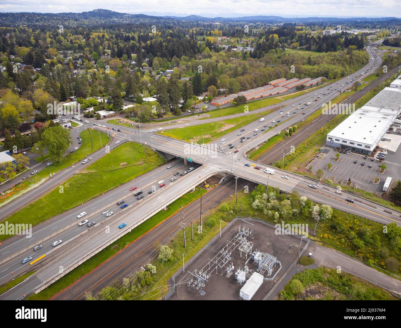 Shot from the air. Central street of a small green town. Highway ...