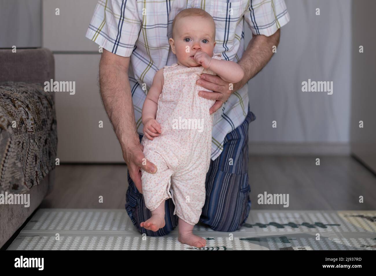 Little toddler infant child make first steps at parent support and care ...
