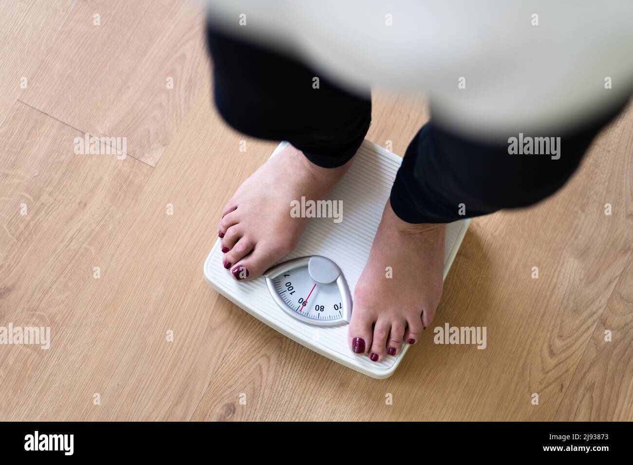 Low Section Of A Person Standing On Weighing Scale Stock Photo - Alamy