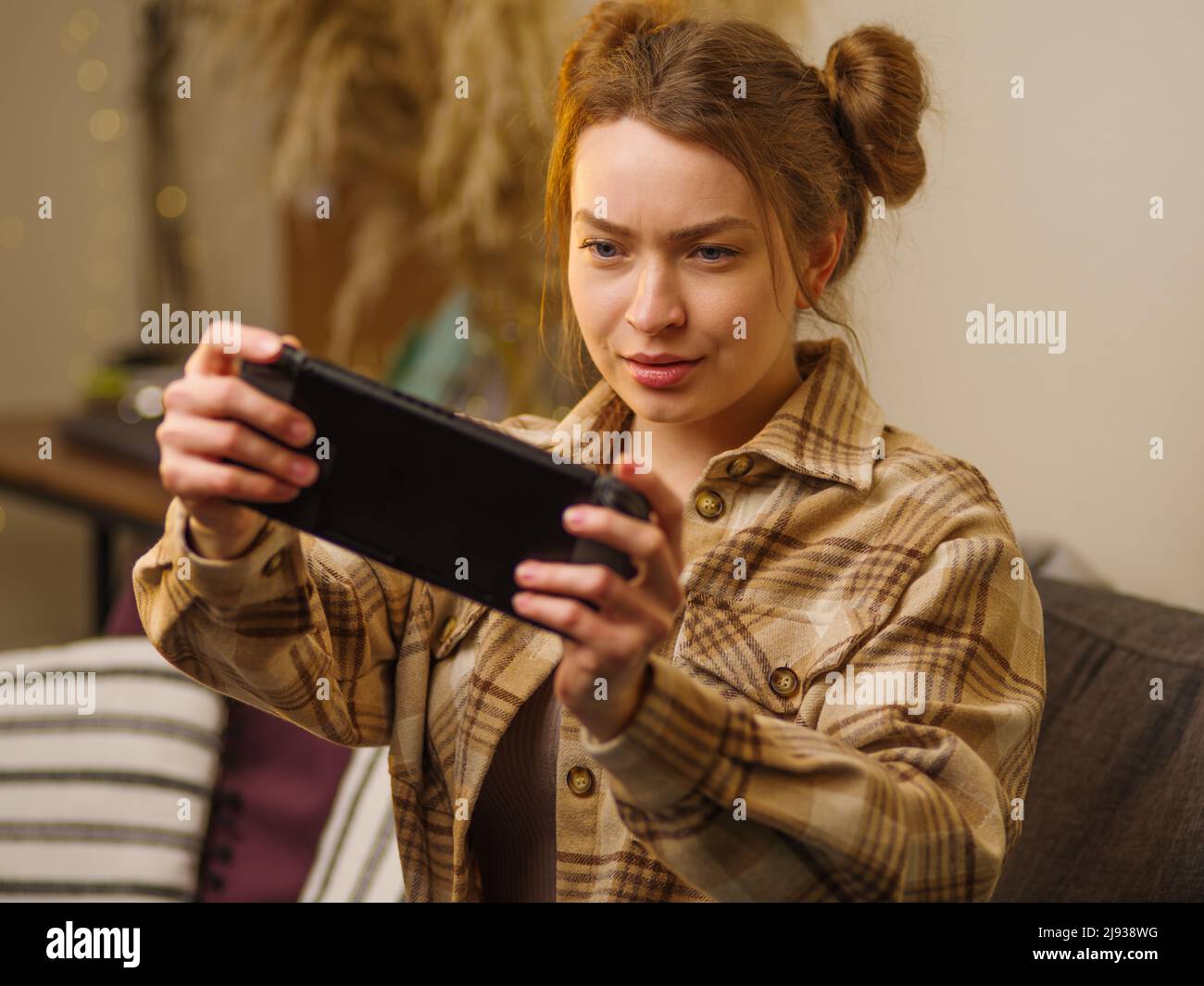A young girl plays video games on a portable game console. Close-up ...