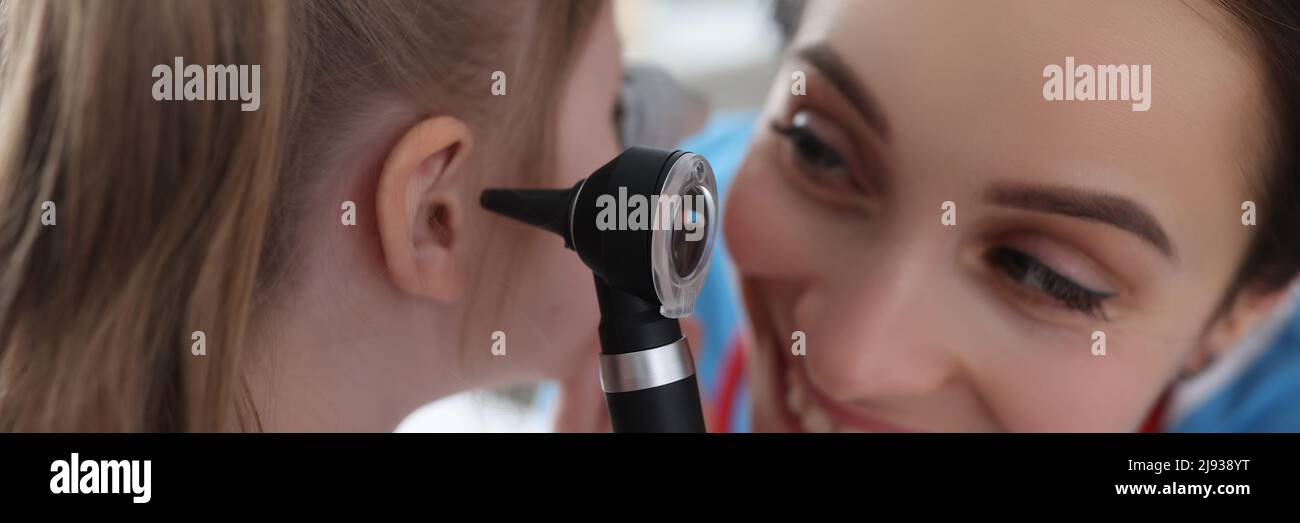 Ent woman examining ear of little girl with otoscope in clinic Stock ...