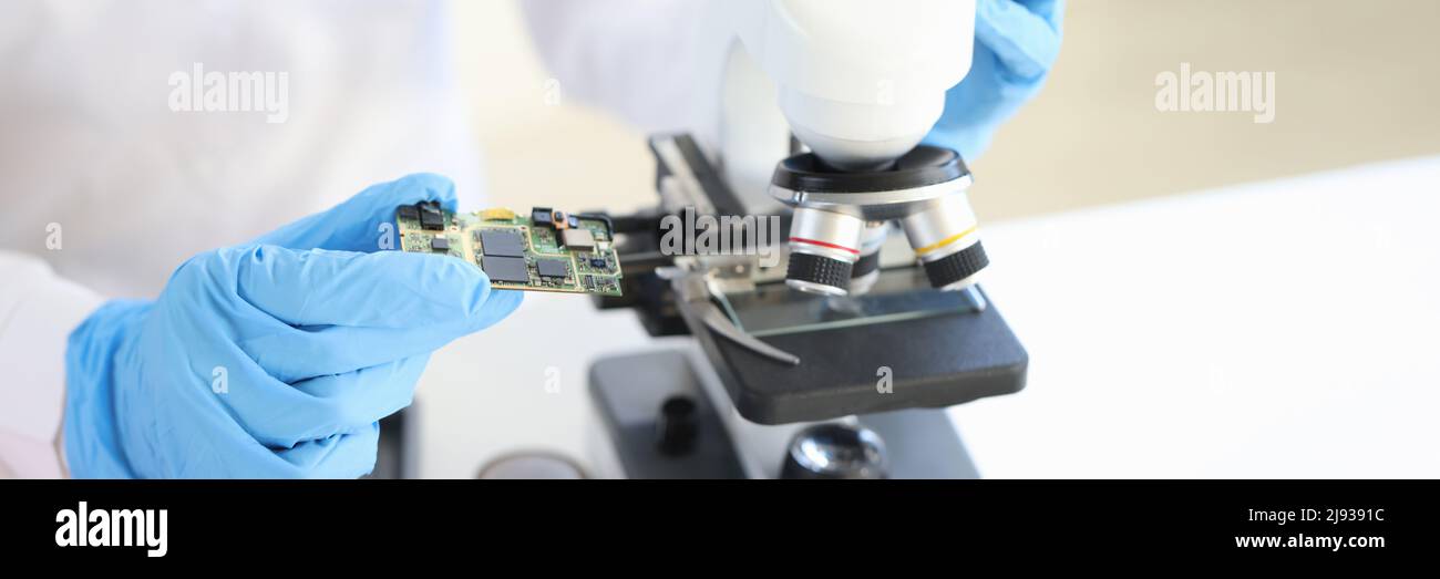 Scientist looking under microscope computer processor closeup Stock ...