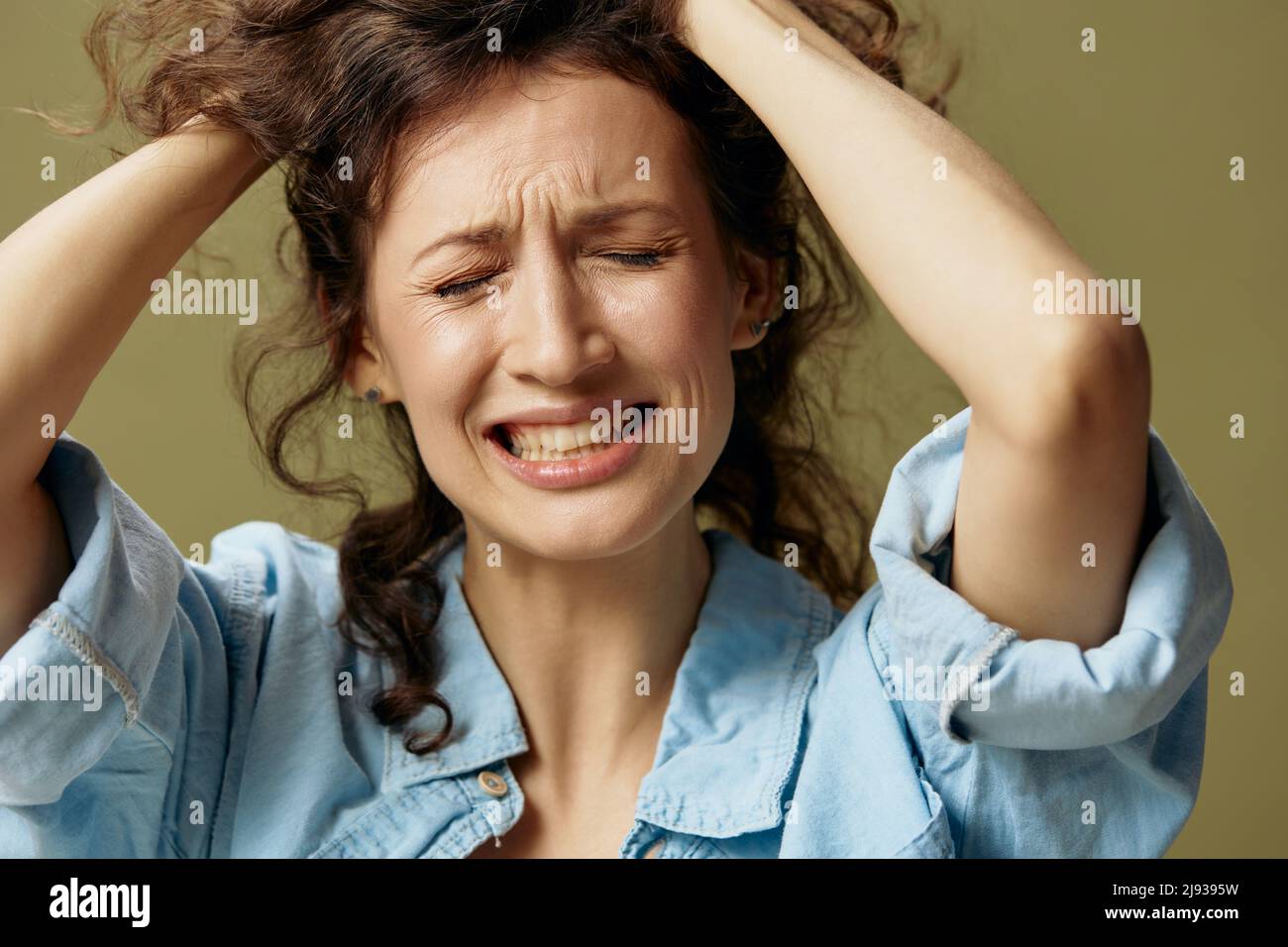 Suffering screaming crying curly beautiful female in jeans casual shirt ...