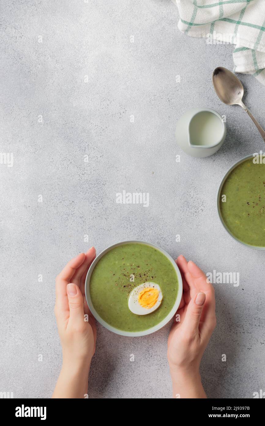 Human hand holding spinach cream soup with boiled egg top view Stock ...