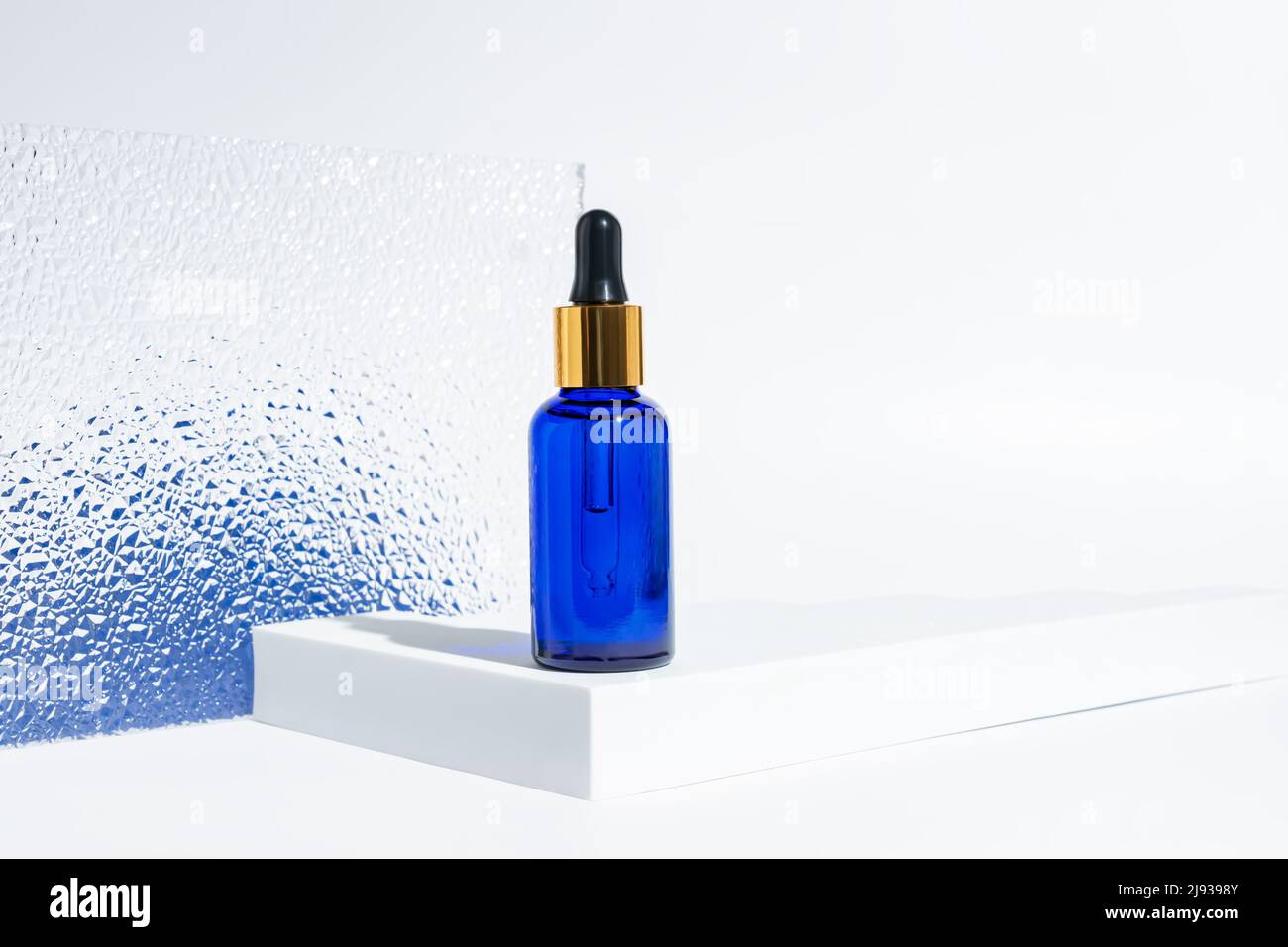blue glass cosmetic bottle with a dropper on a white background with ...