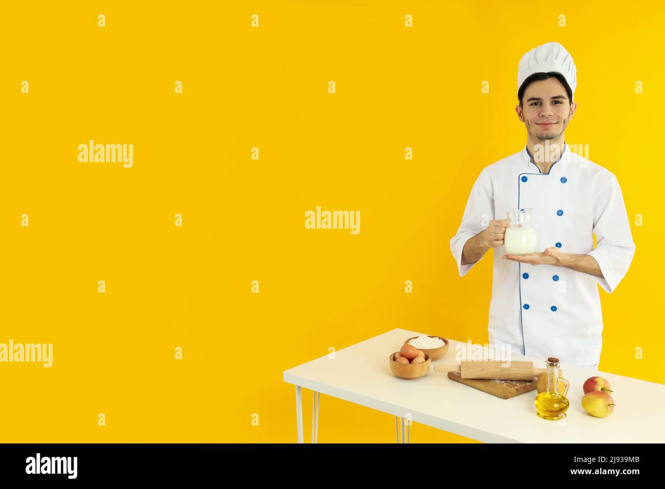 Concept of cooking, young man chef on yellow background Stock Photo - Alamy