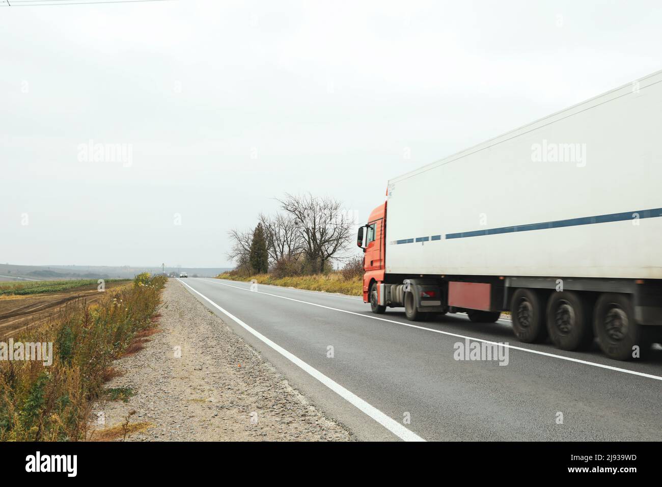 Truck rides on asphalt road in autumn Stock Photo - Alamy