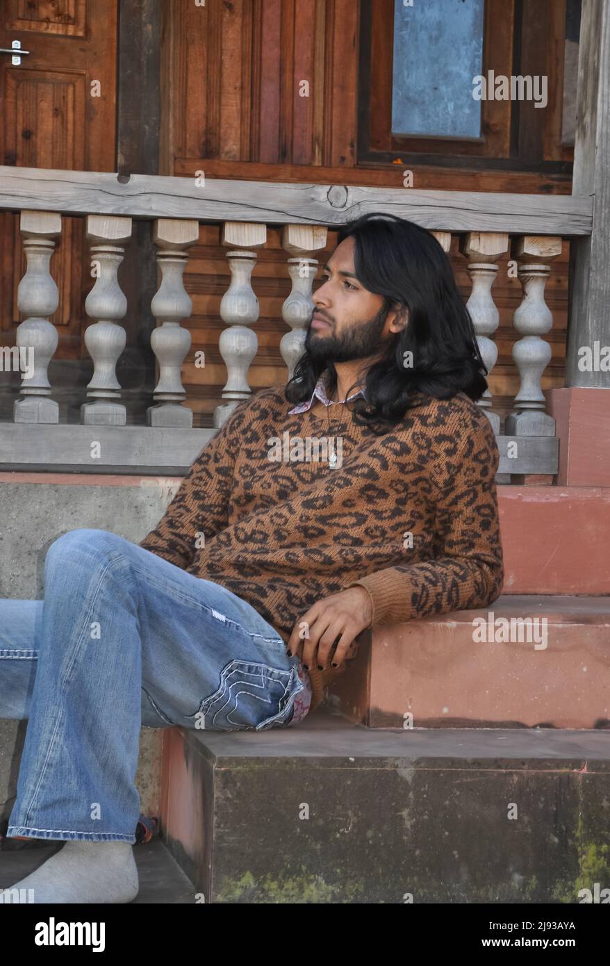 Side view of a good looking Indian young guy with long hair style ...