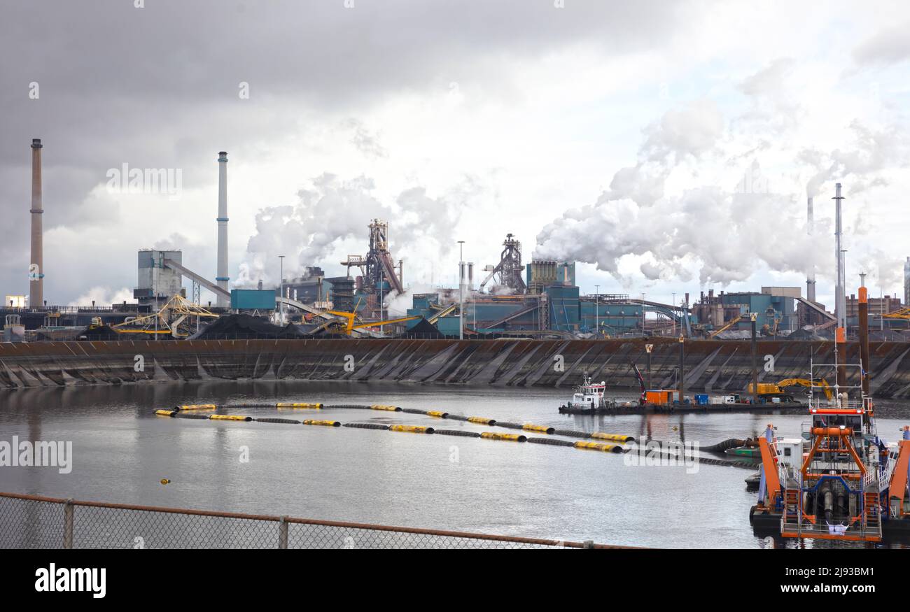 Steel factory plant with chimneys in the Netherlands, ship in front ...