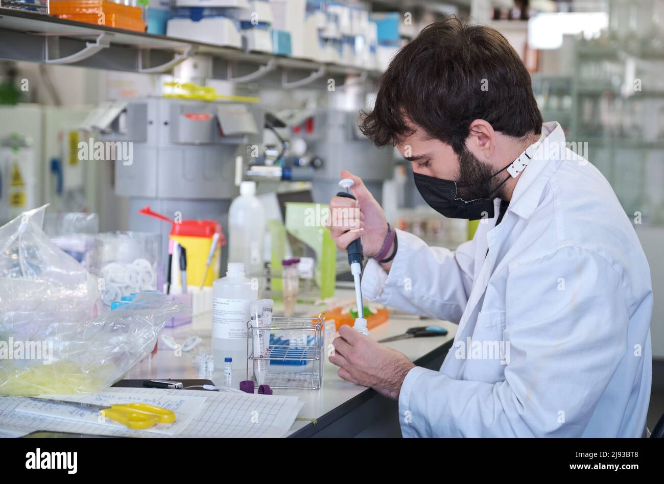 Young researcher wearing protective face mask working in a real ...