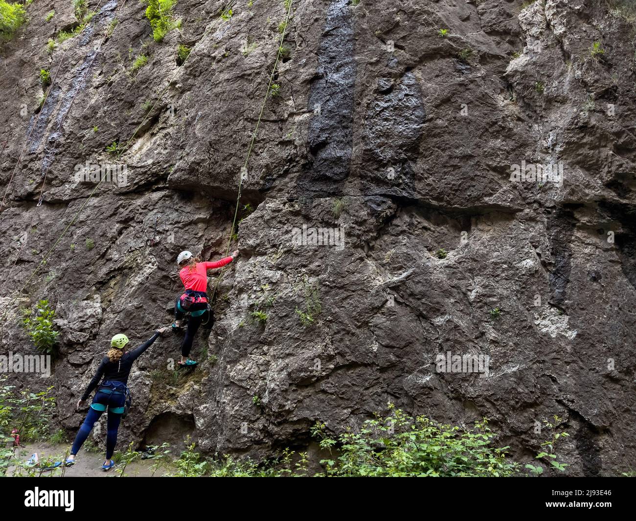 Climber people climbing a natural rocky wall Stock Photo - Alamy