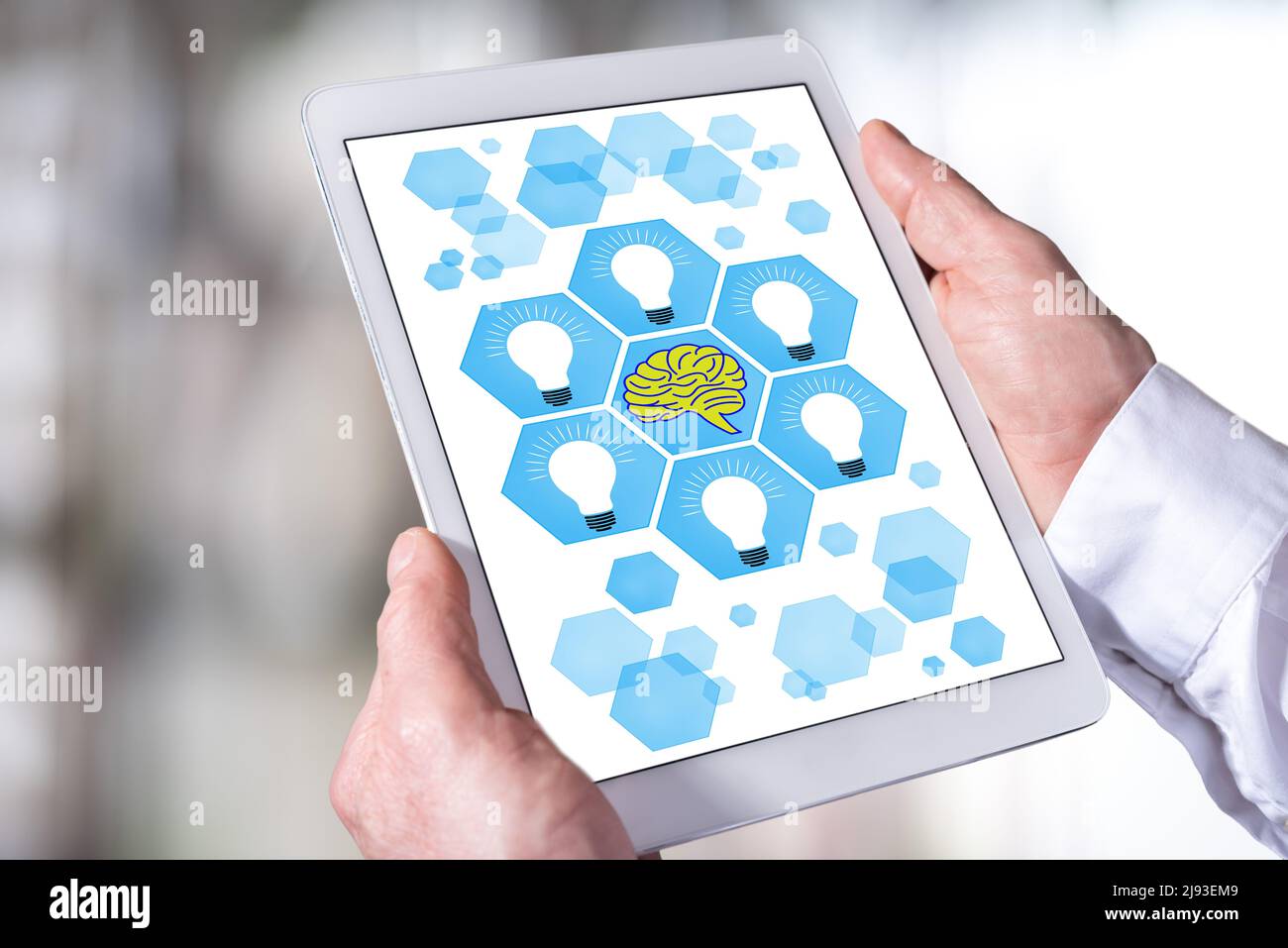 Man holding a tablet showing human brain ideas concept Stock Photo - Alamy