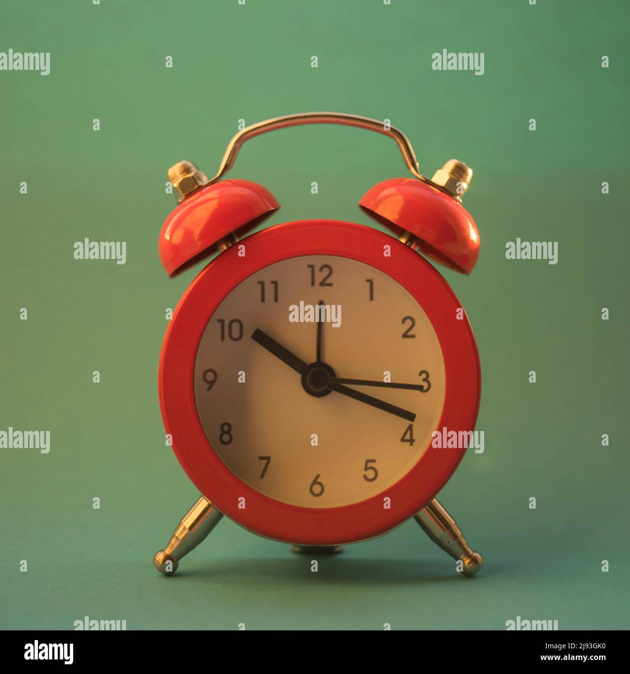 new red round clock on green table, side view Stock Photo - Alamy