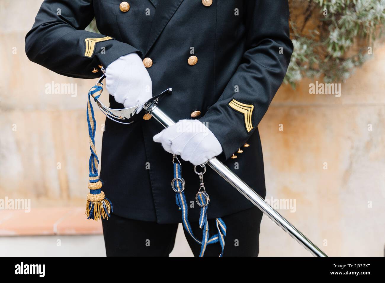 A courageous man in a uniform, white gloves on his hands, draws a sword ...