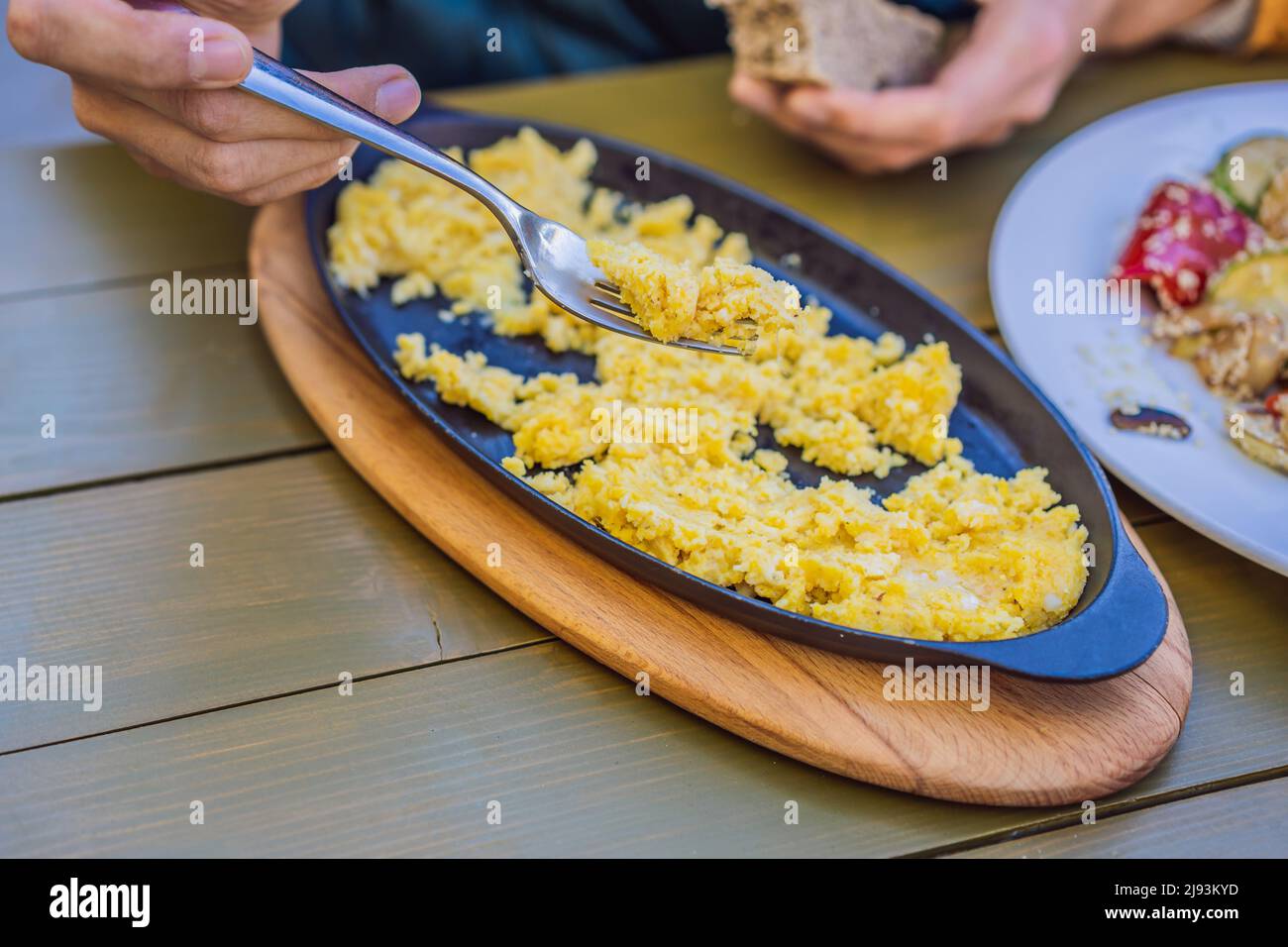 Traditional Montenegrin Meal. Kacamak in a black pan Stock Photo - Alamy