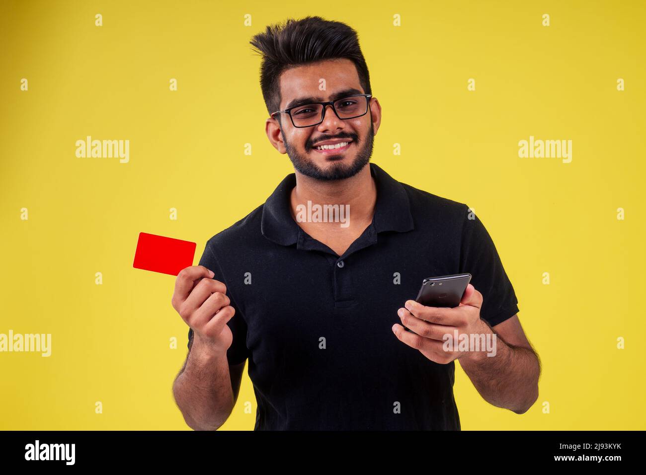 Young man holding business card in studio yellow background Stock Photo ...
