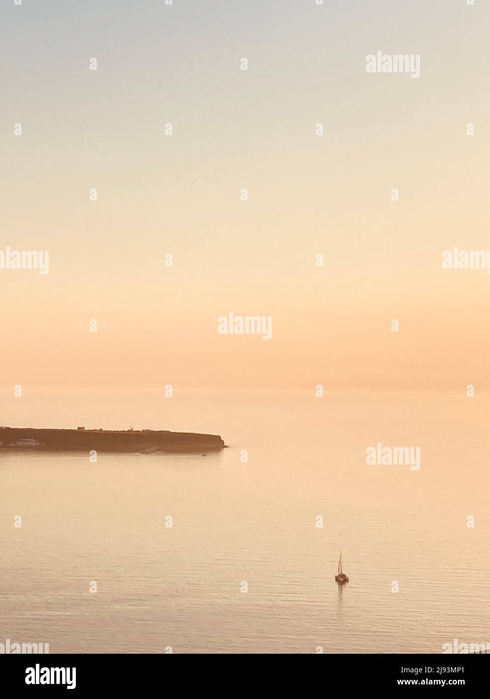 a small boat and jetty at sunset on the Greek island of Santorini Stock ...