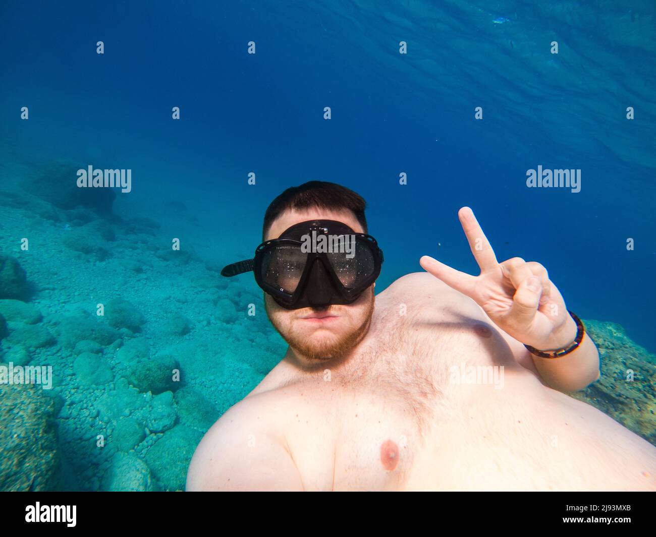 man underwater in scuba mask diving under water taking selfie picture ...