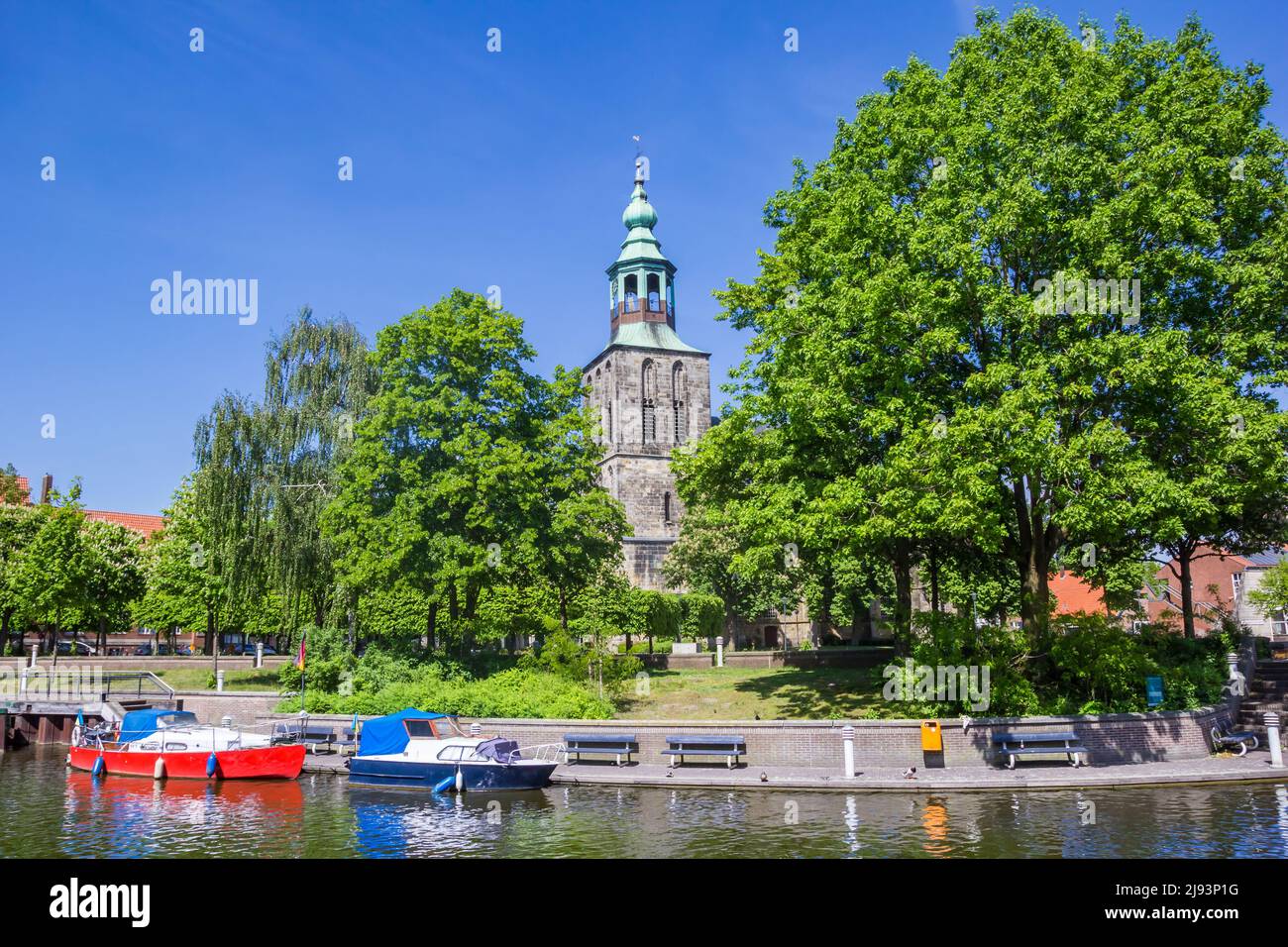 Boats in the Vechte river in front of the historic church tower of ...