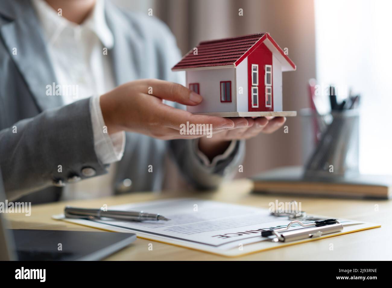 Insurance concept the property dealer presenting the new model of house ...