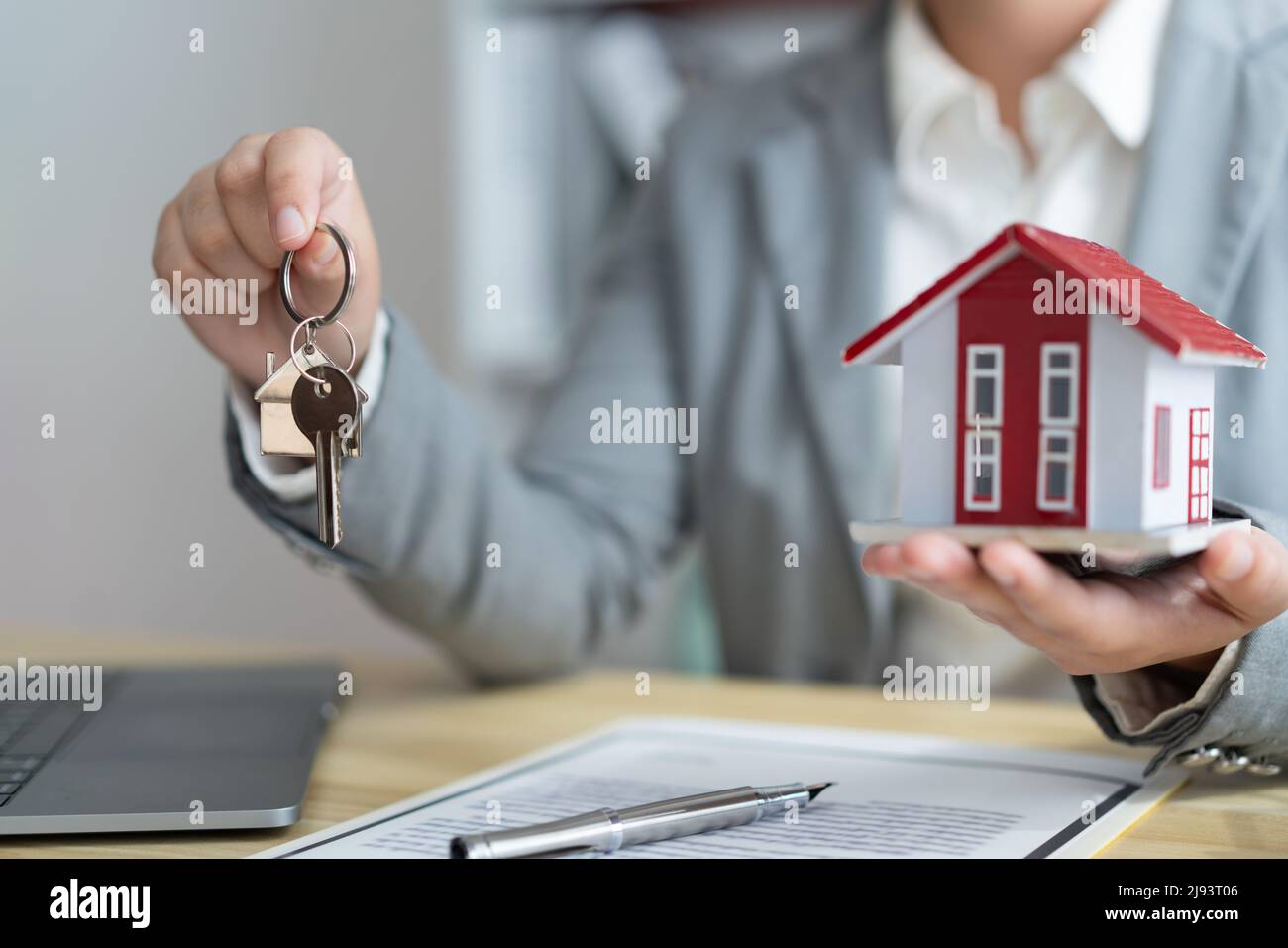 Insurance concept the real estate representative holding a house key on ...