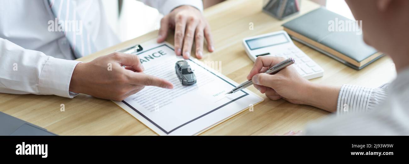 Insurance concept the male dealer suggesting his customer to sign the ...