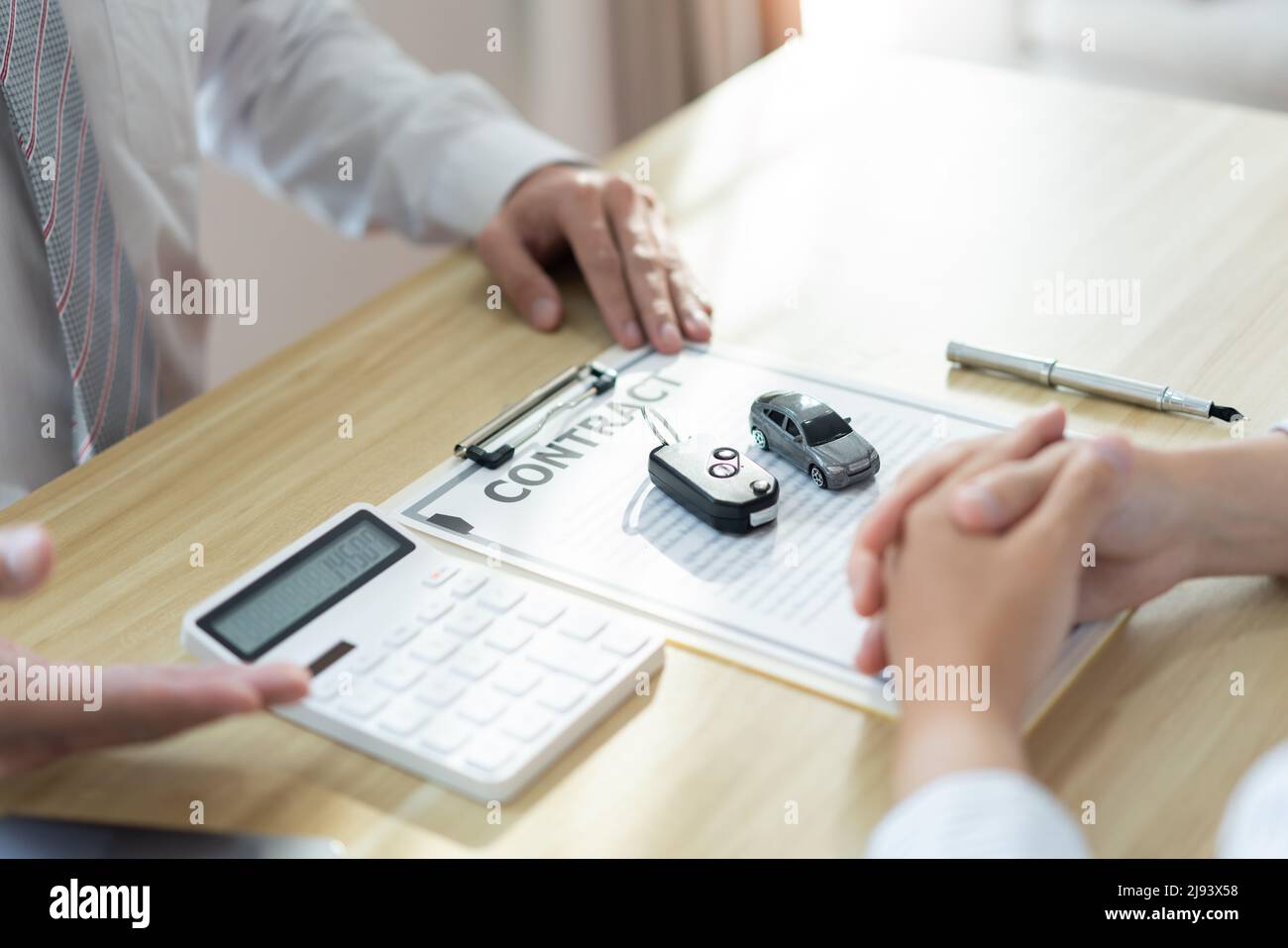 Insurance concept the male dealer suggesting his customer to sign the ...